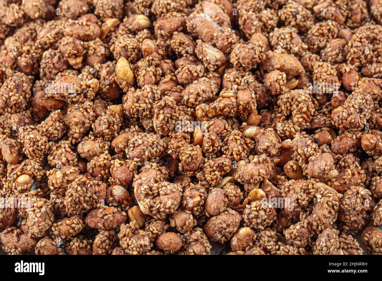 Honey with sesame peanuts (peanuts with sesame). Close-up view of brown ...