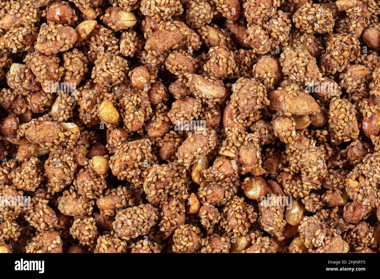 Honey with sesame peanuts (peanuts with sesame). Close-up view of brown ...