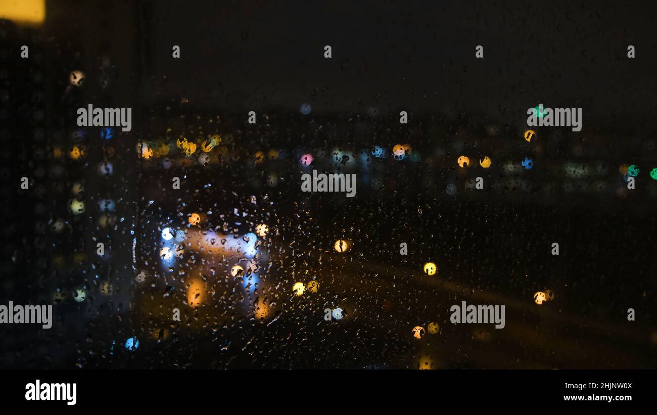 Raindrops on a window surface at night. Concept. Close-up of raindrops ...
