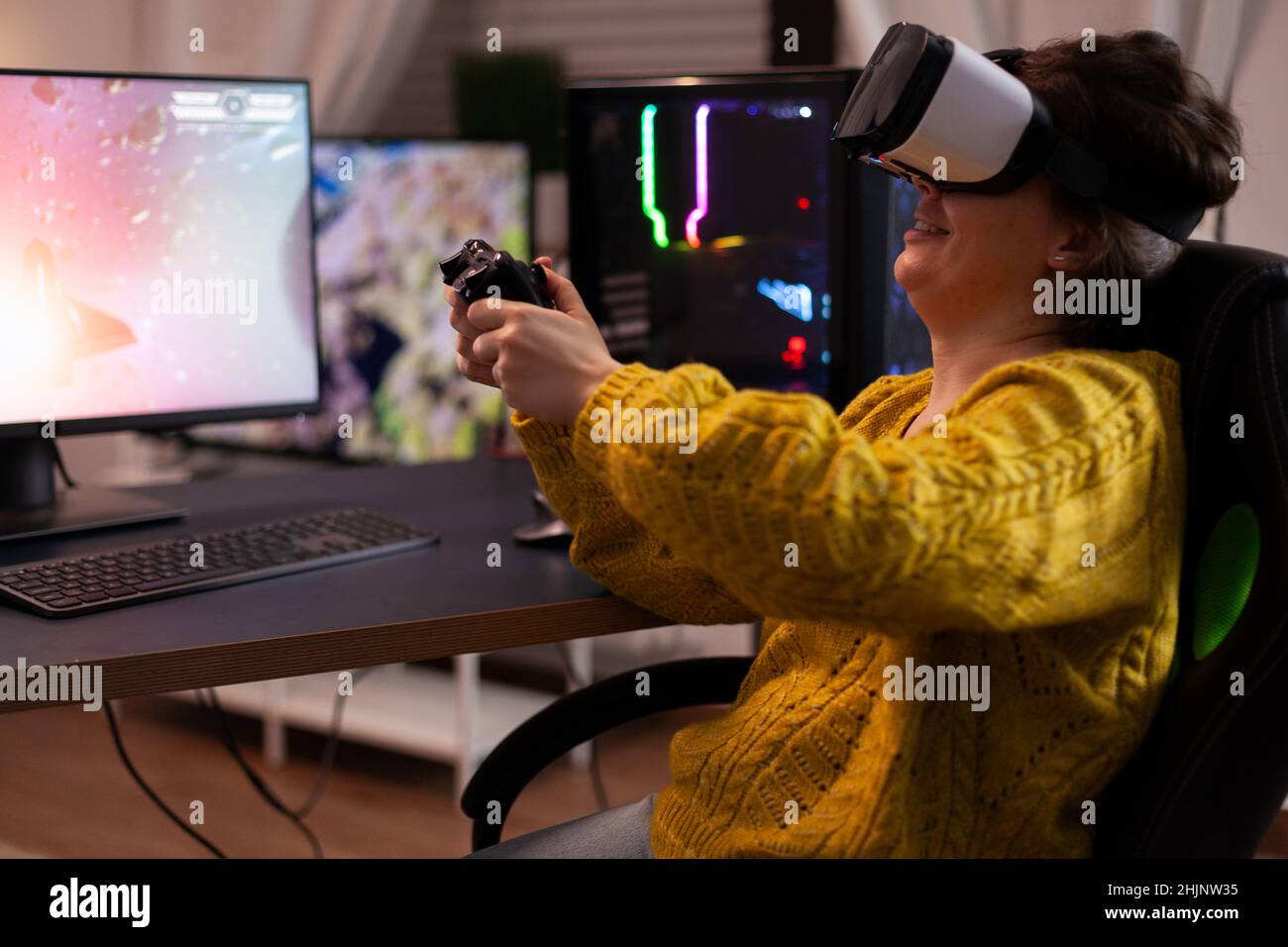 Woman gamer wearing virtual reality goggles holding joystick playing ...