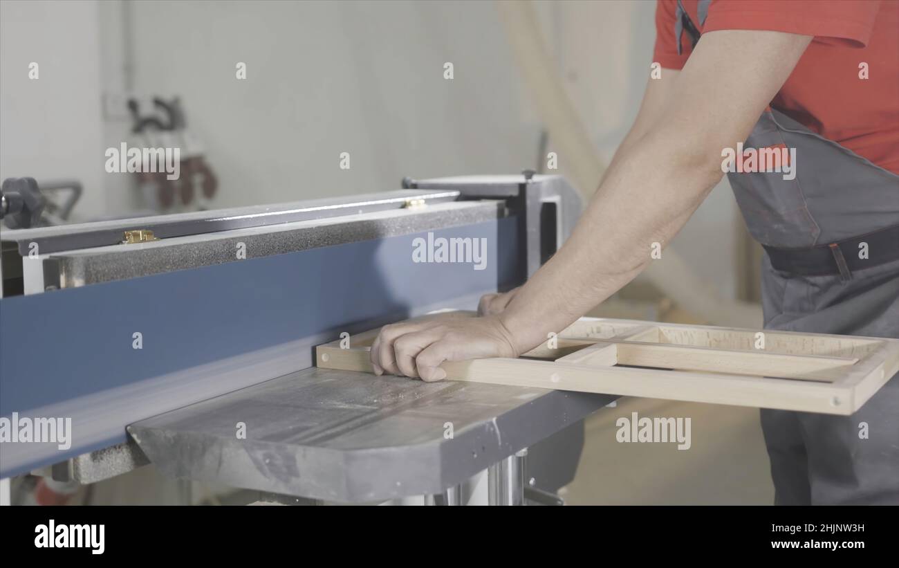 Wood surface grinding machine. Action. Professional carpenter grinds ...