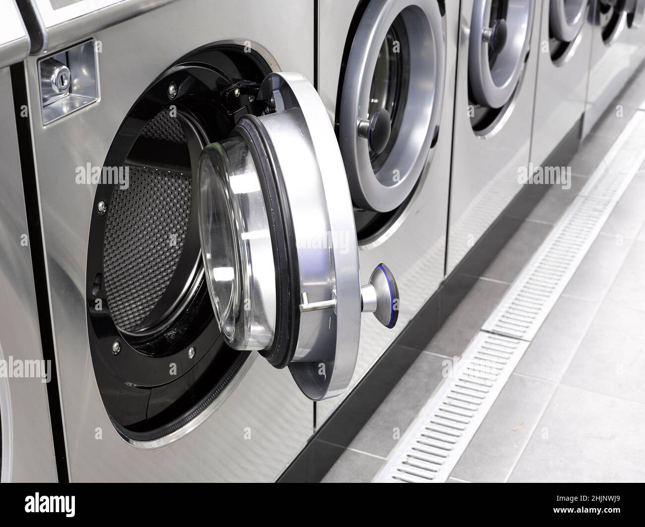 Industrial washing machines in a public laundromat Stock Photo - Alamy
