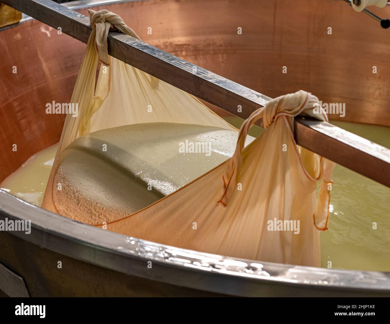 Closeup of the process of making parmesan cheese (parmigiana) in a big ...