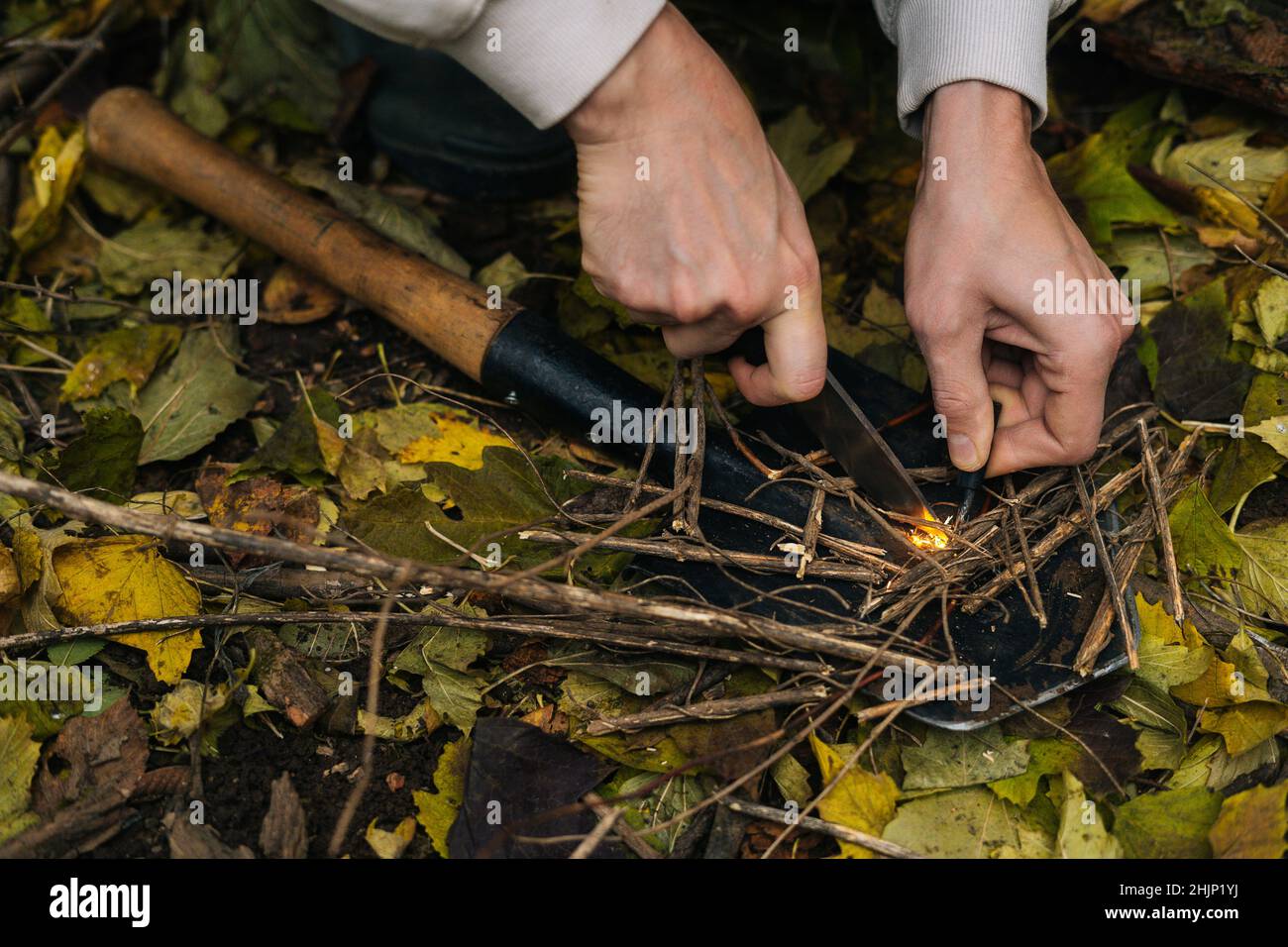 Close-up cropped shot of unrecognizable tourist male lighting fire ...
