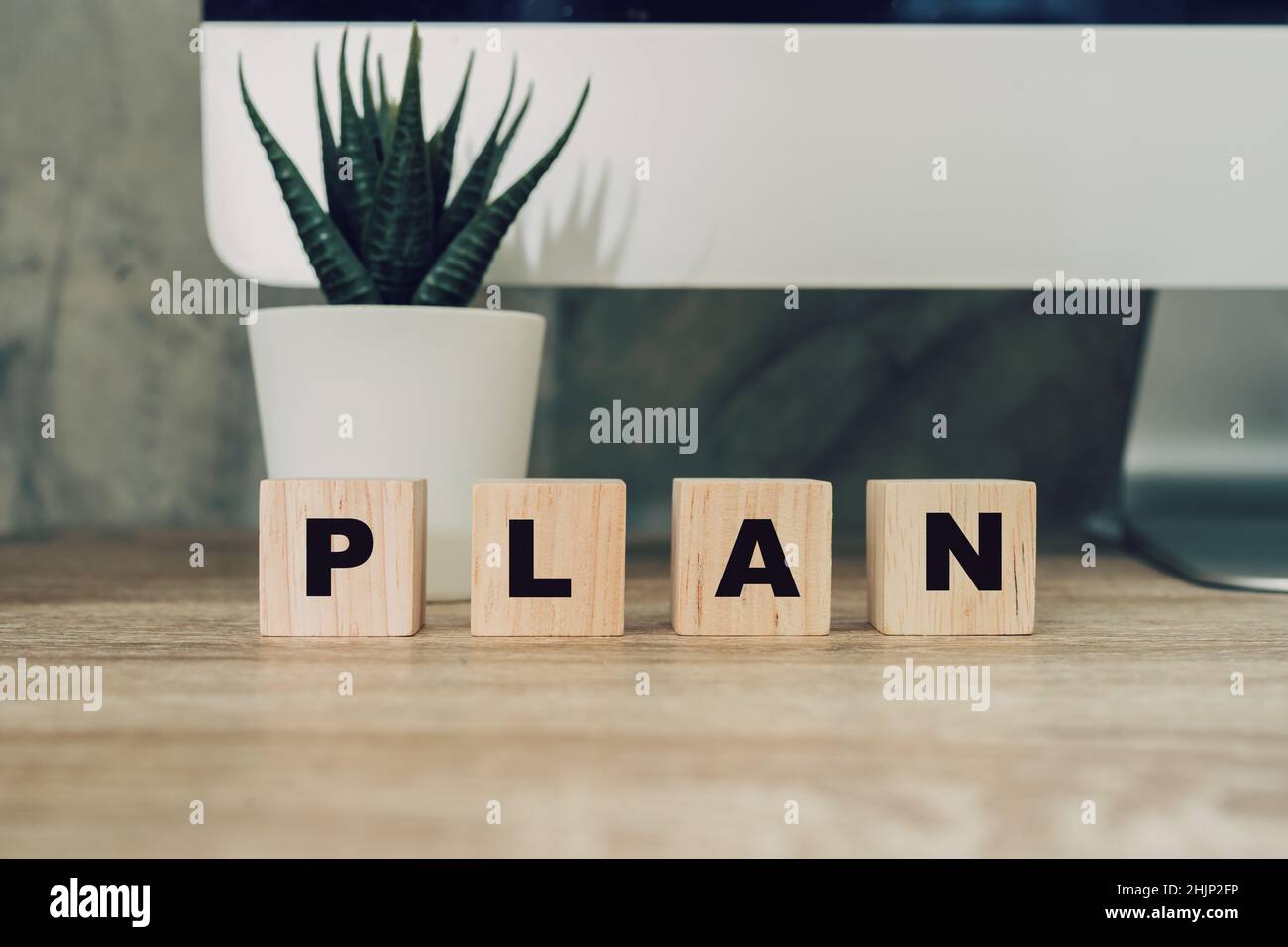 Wooden block cube with alphabet text "PLAN" on wood table. education ...