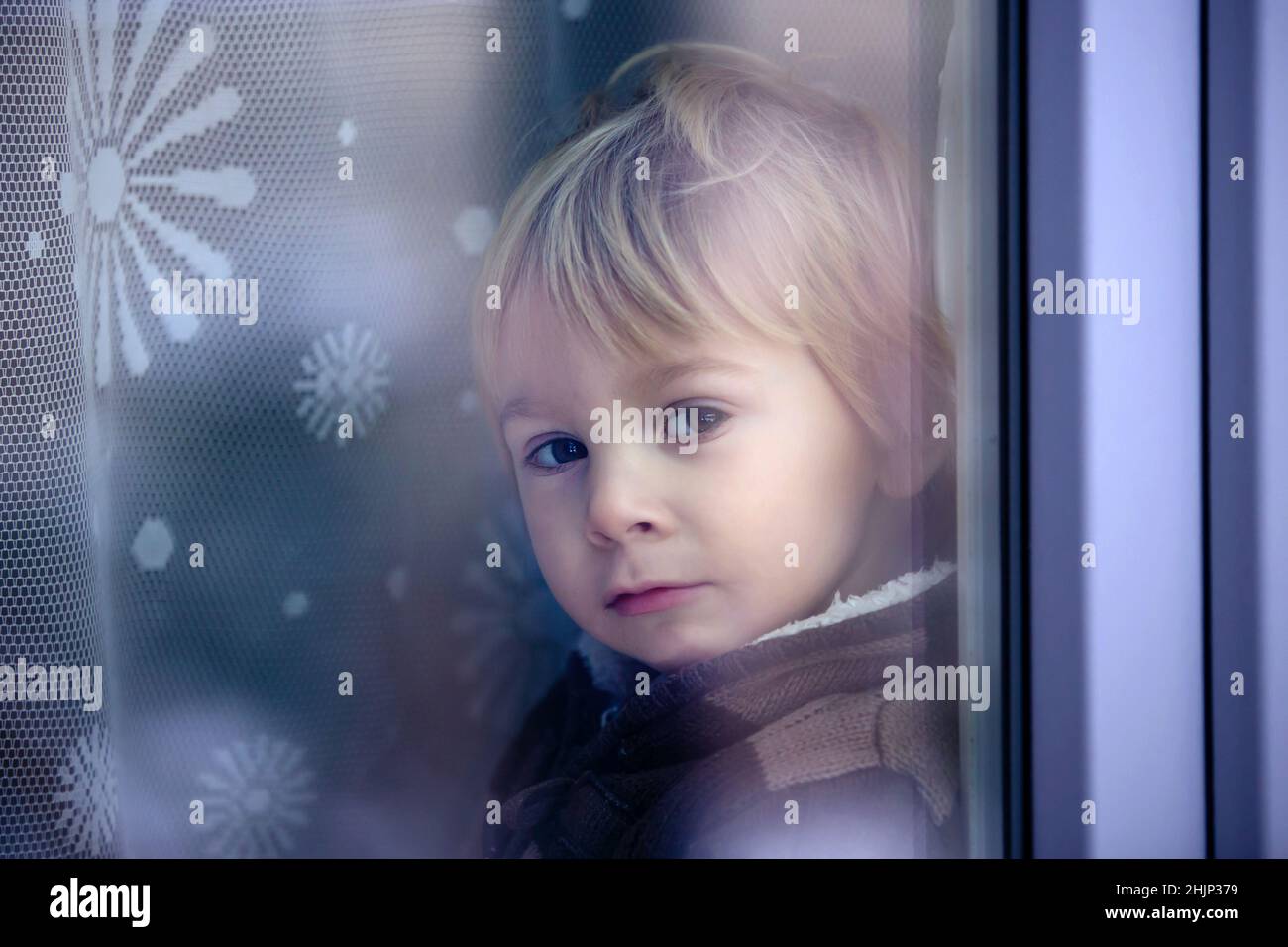 Little toddler boy, sitting behind the window, looking outside Stock ...