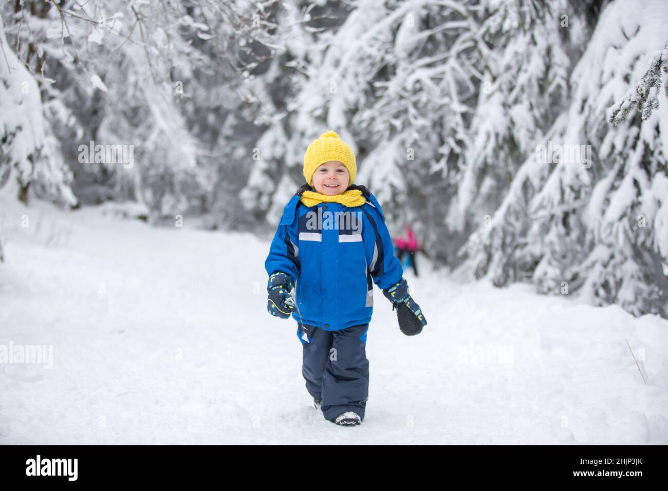 Sweet happy child, playing in deep snow in forest Stock Photo - Alamy