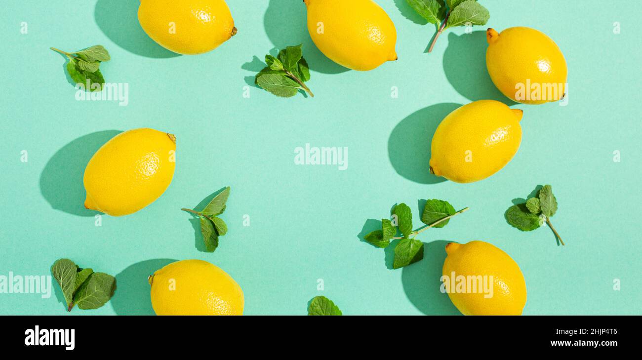 Lemons with mint on minimal blue background sun light hard shadows ...