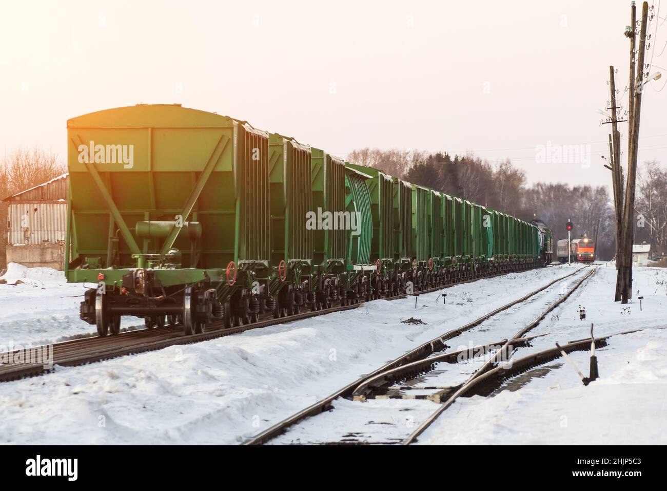 A freight train with a small train of hopper cars, at a small station ...