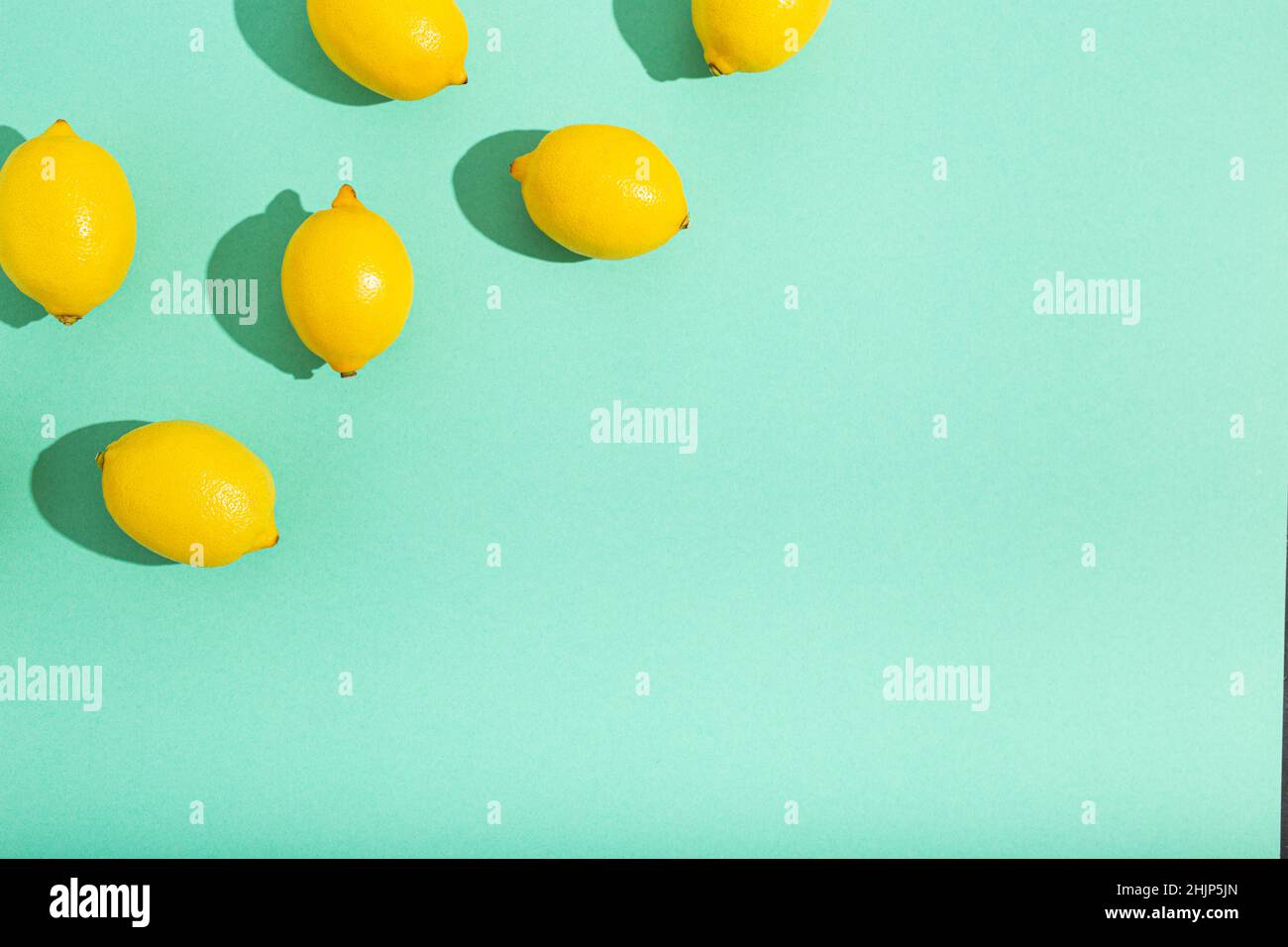 yellow whole lemons on minimal blue background on bright sun light with ...