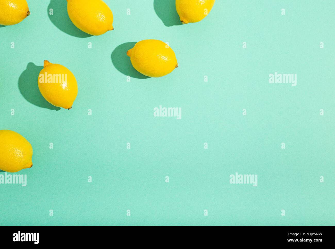 yellow whole lemons on minimal blue background on bright sun light with ...