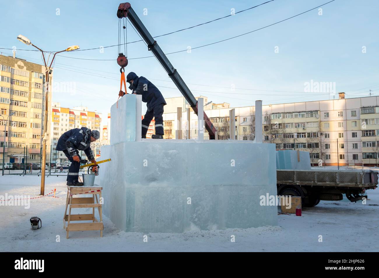 Installers adjust and install another ice block to the overall ...