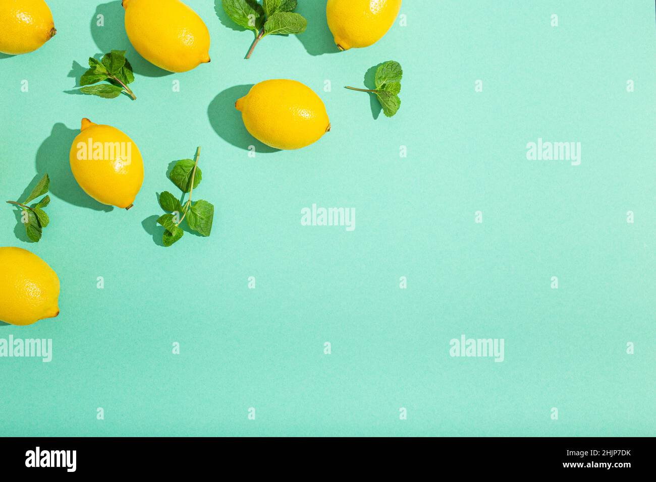 Lemons with mint on minimal blue background sun light hard shadows ...