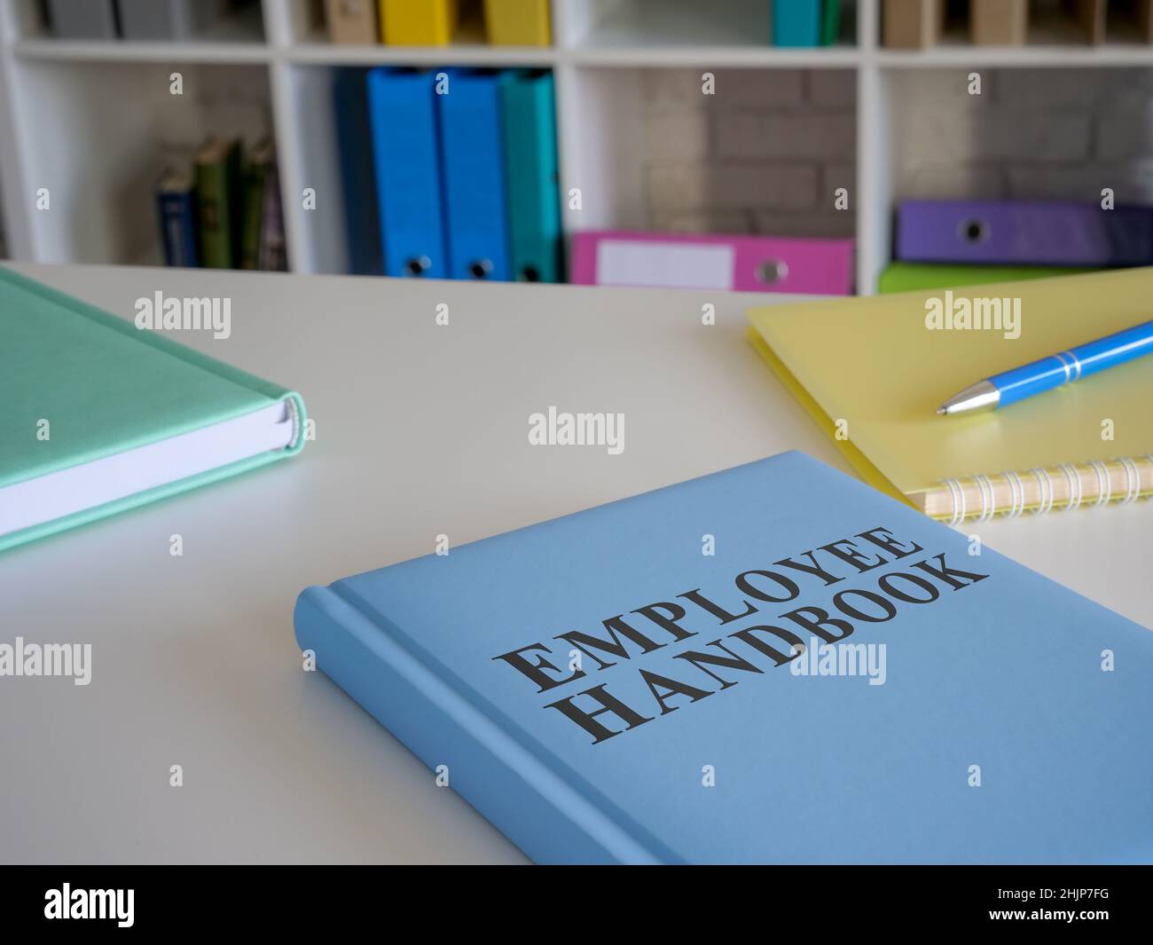 Blue employee handbook on the office desk Stock Photo - Alamy