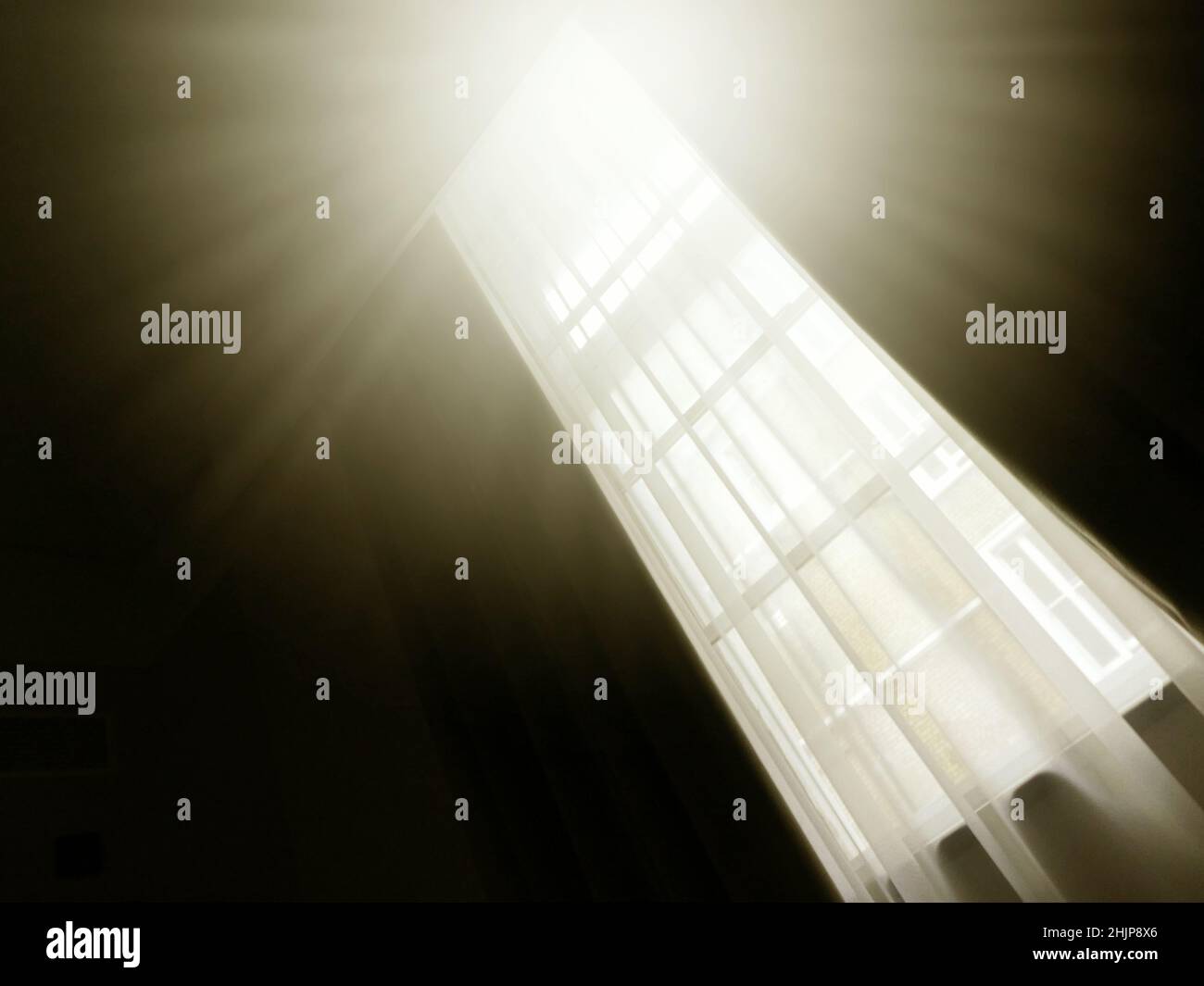 semi-abstract picture of long tall window with sunlight streaming in ...