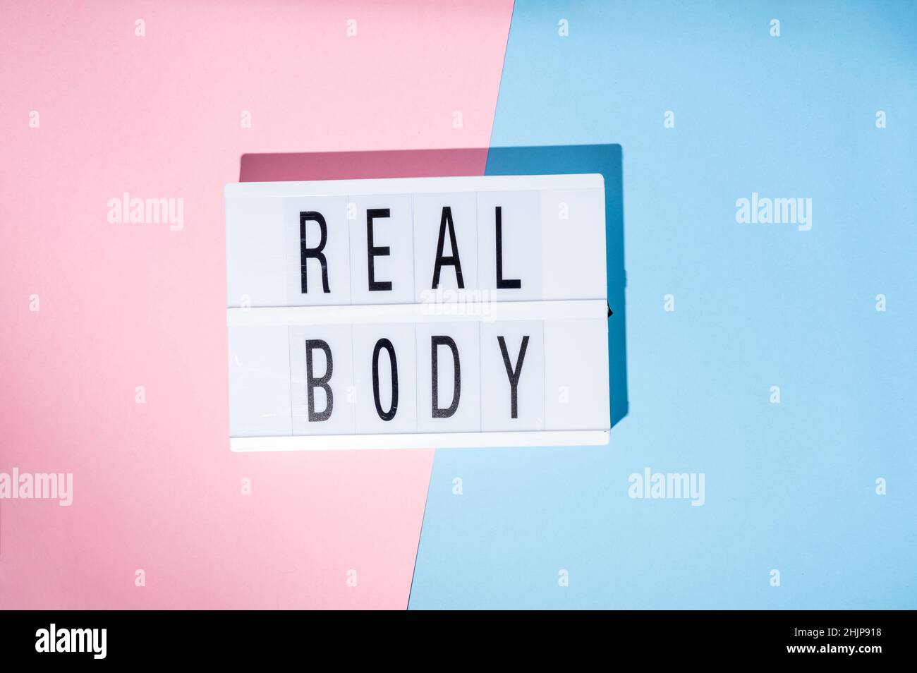 Real Body text on the lightbox. Concept of feminism on a blue and pink ...