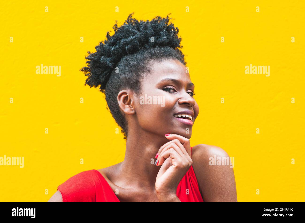 Portrait of a beautiful black colombian model laughing on a yellow ...
