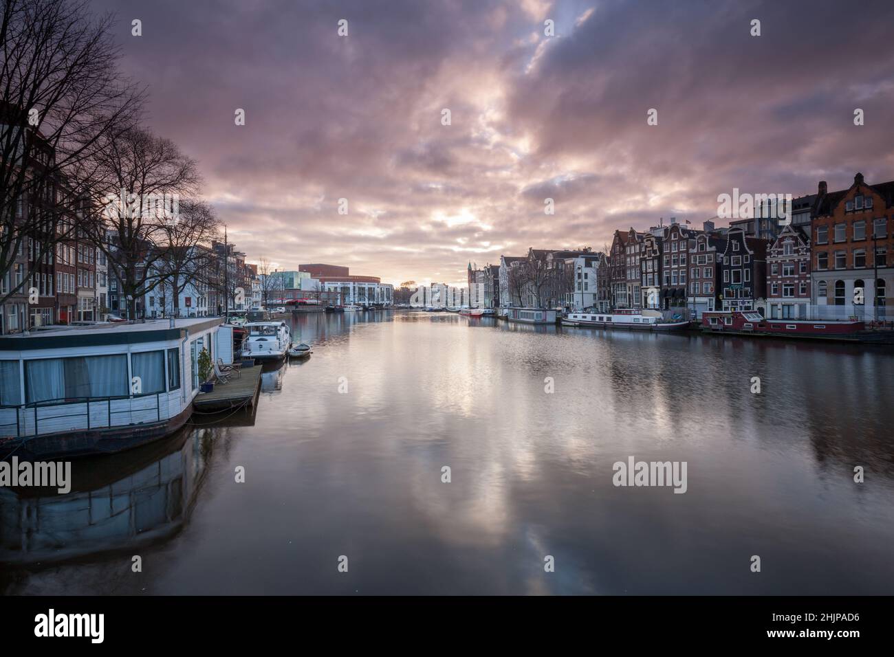 Amsterdam canal view at sunrise with house boats and moored river ...