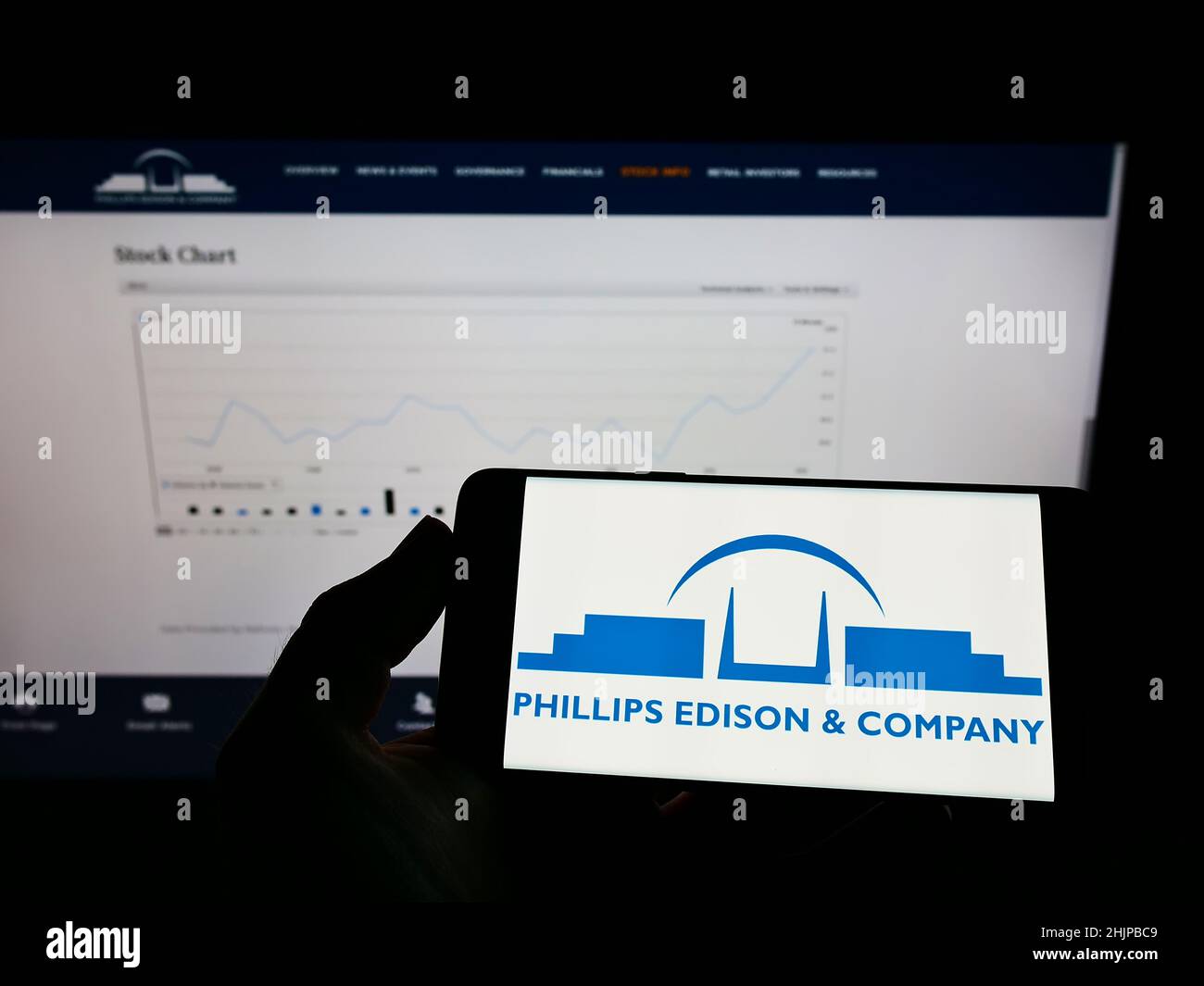 Person holding mobile phone with logo of US real estate business ...