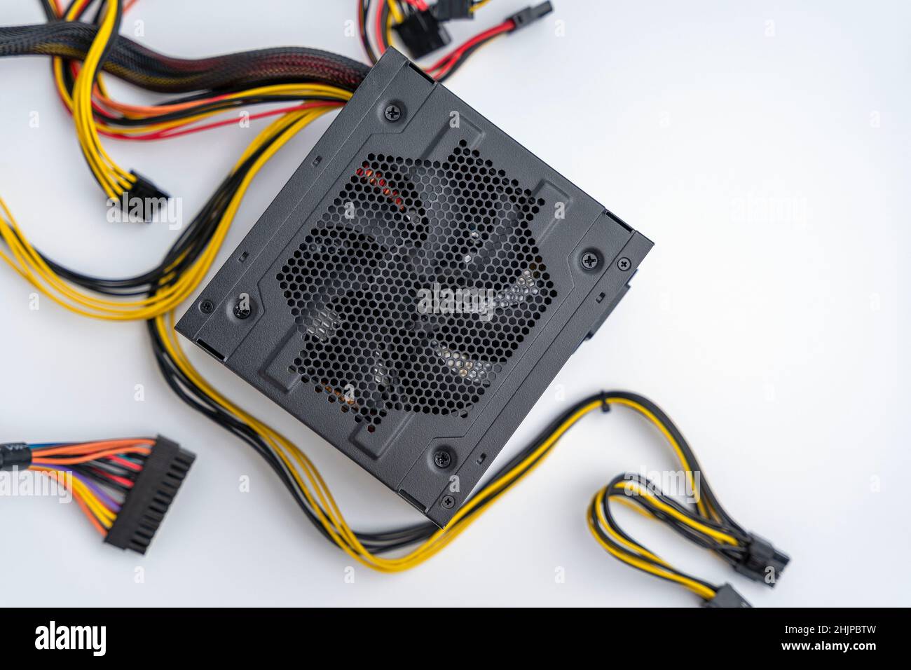 a powerful new computer power supply with connection cables on a white ...