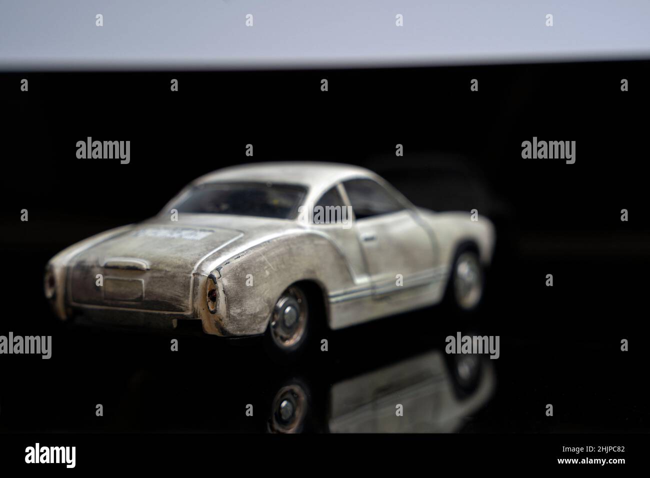 a model of an old classic shabby car on glossy black glass. close-up ...