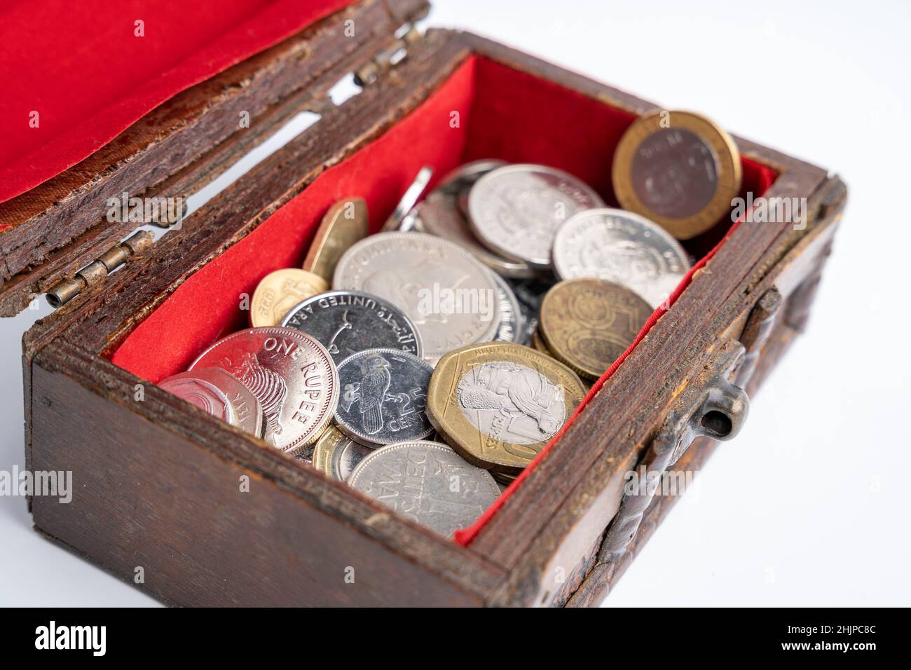 a small old wooden chest with coins on a white background. savings and ...