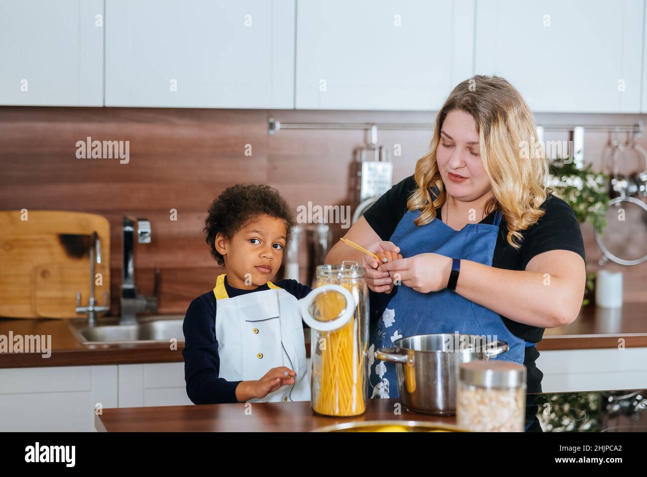 Mom and daughter cook spaghetti in the kitchen Stock Photo - Alamy