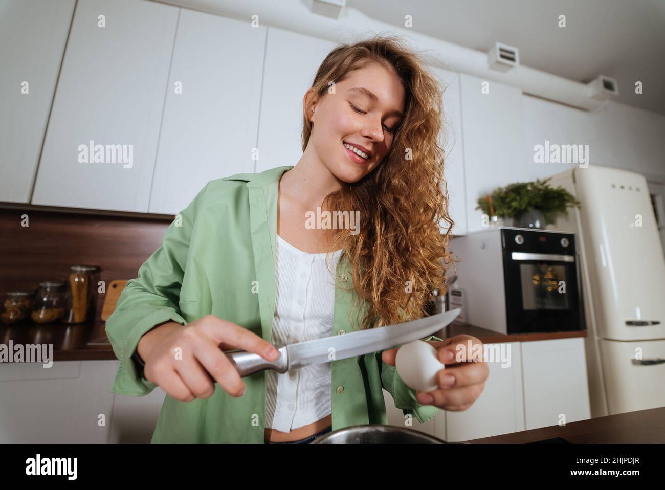 Young woman is preparing food in the kitchen. Beating eggs Stock Photo ...