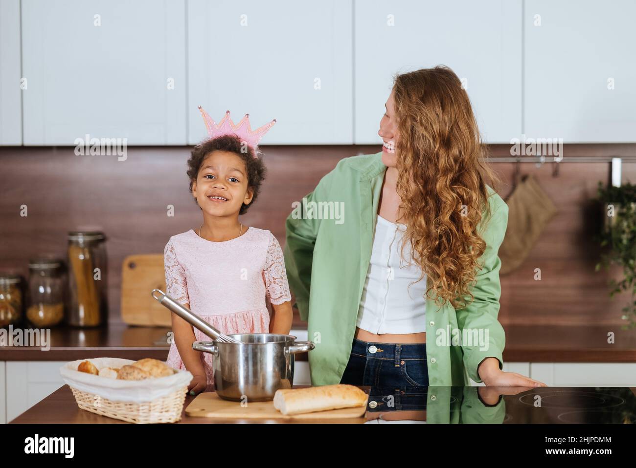 Happy mommy and daughter girl having fun while cooking in kitchen Stock ...
