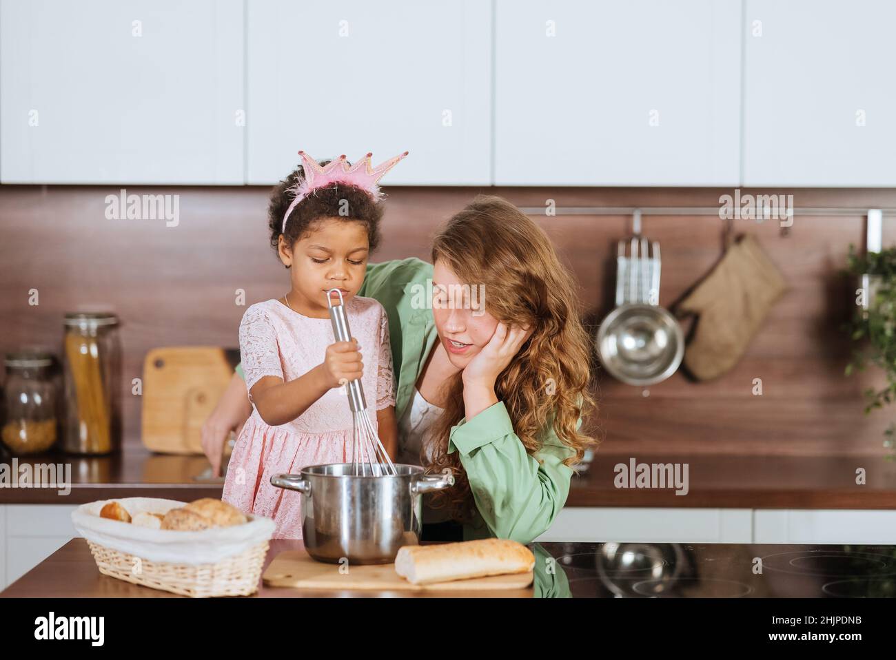 Happy mommy and daughter girl having fun while cooking in kitchen Stock ...