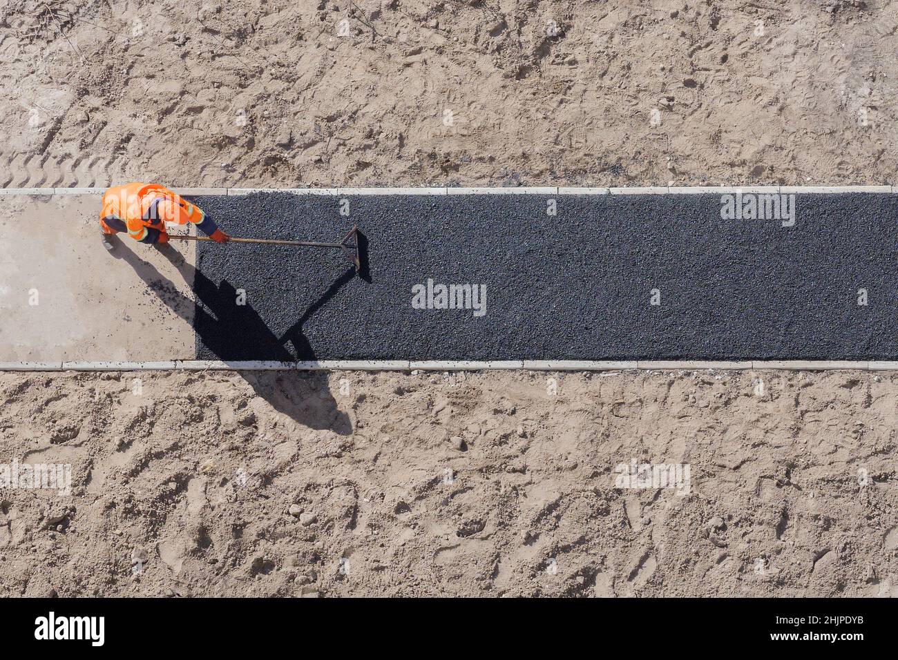 Laying worker new asphalt paving road construction site work pathway ...
