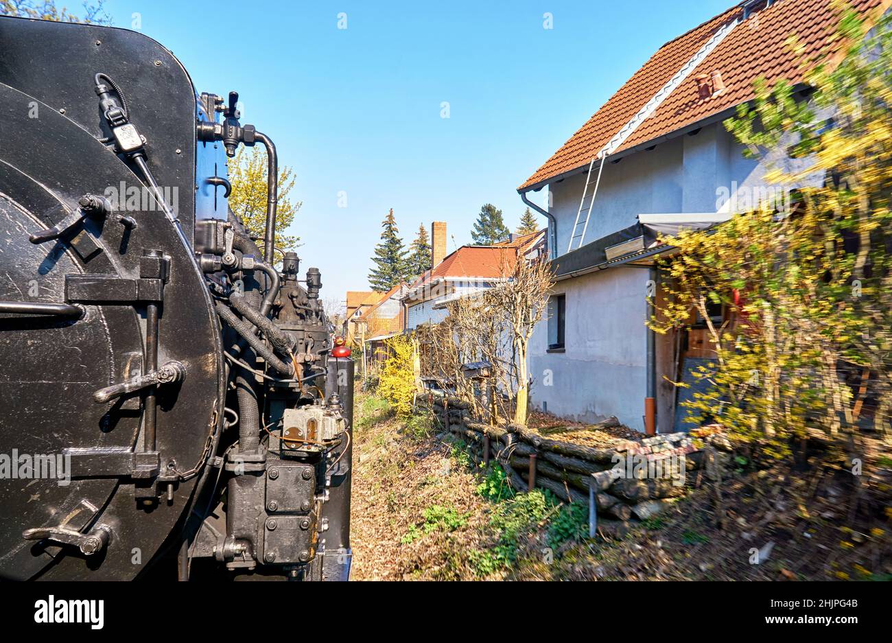 Old steam locomotive drives very close to a house wall. Dynamic through ...