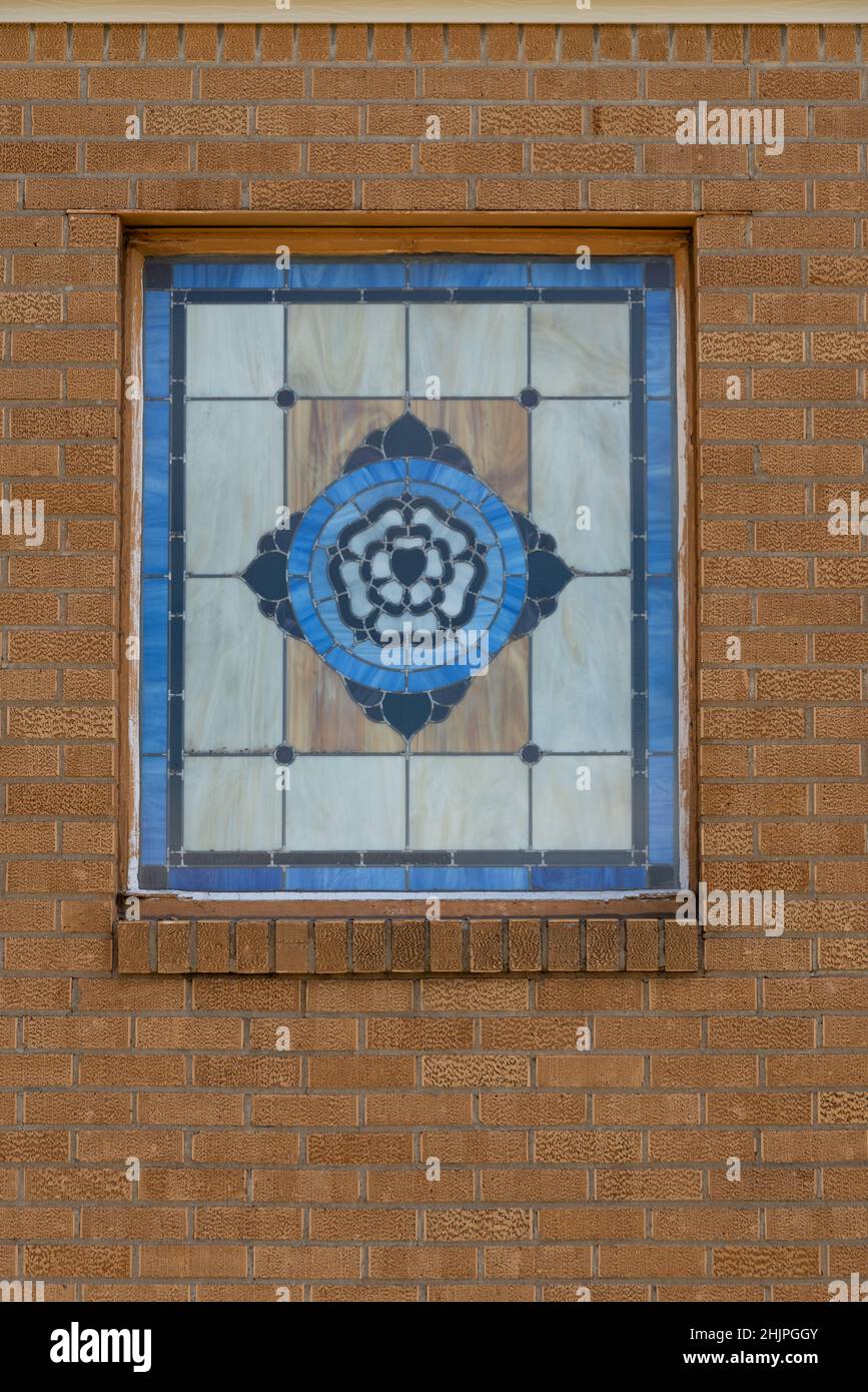 Closeup of a blue, white and beige square stained glass window, a ...