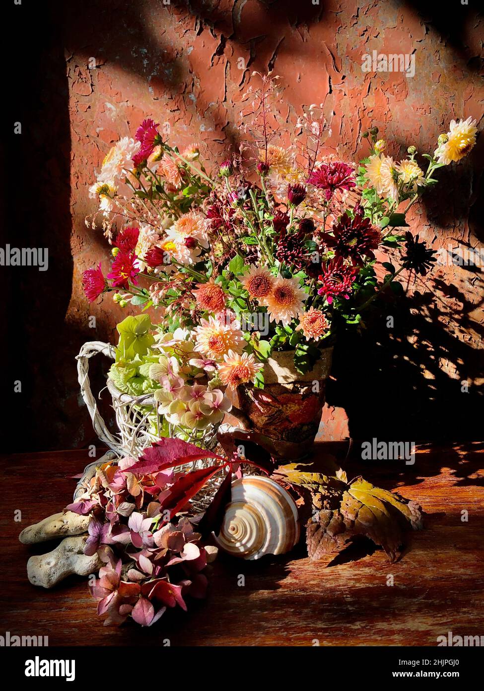 A bouquet with autumn flowers in a glass flask with pale pink flowers ...
