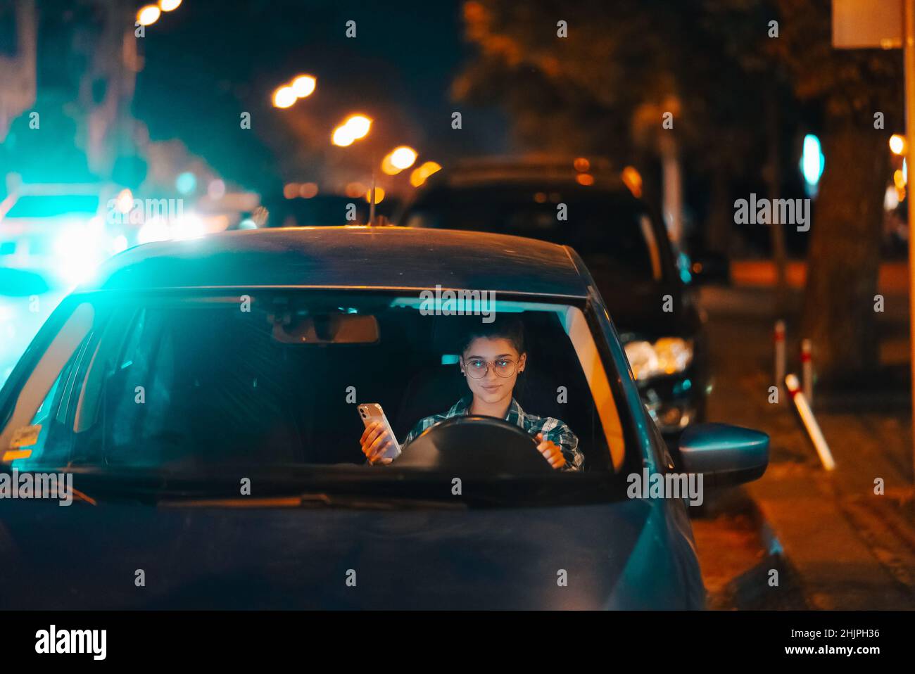 Lost female driver using mobile phone while driving at night Stock ...