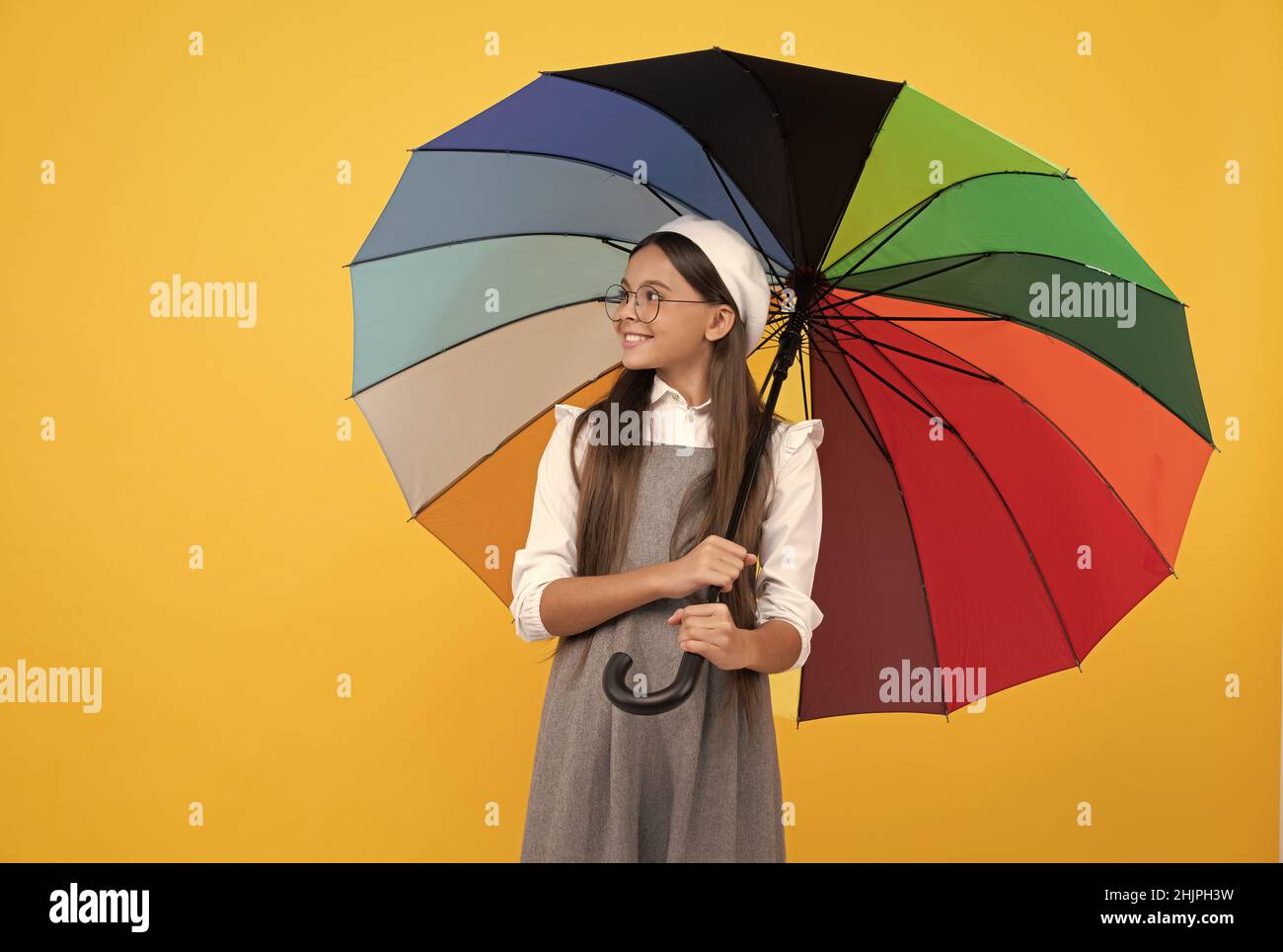 happy teen girl in beret under colorful umbrella for rain protection in ...