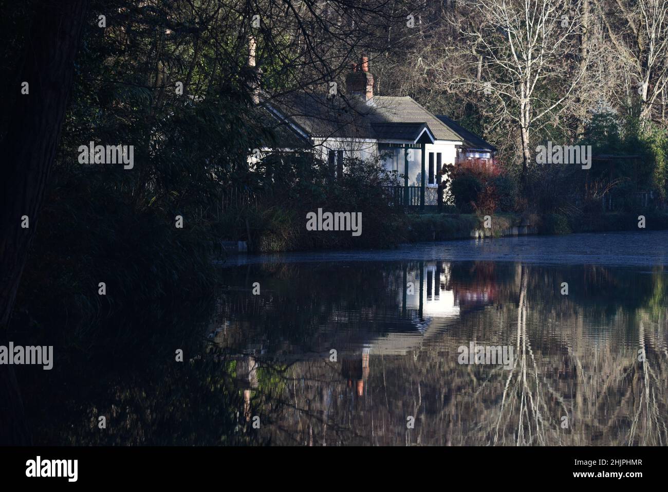 The old cottage is reflected in the still waters of the beautiful ...