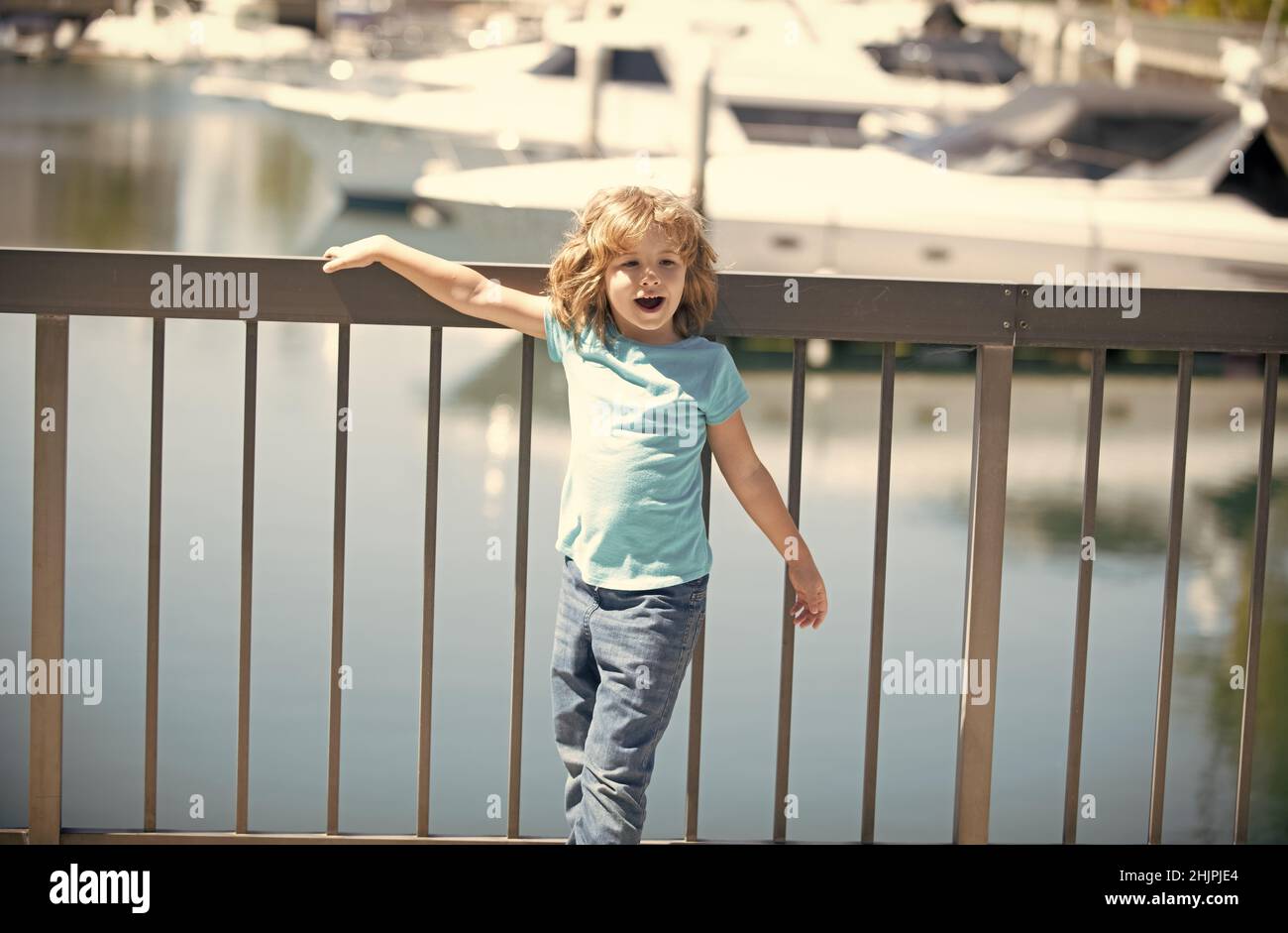 Vacation time. Happy kid stand at quay railing. Summer vacation ...