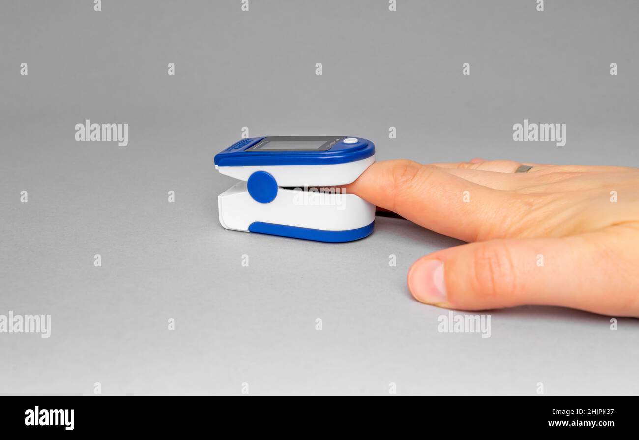 Pulse oximeter on a female hand Stock Photo - Alamy