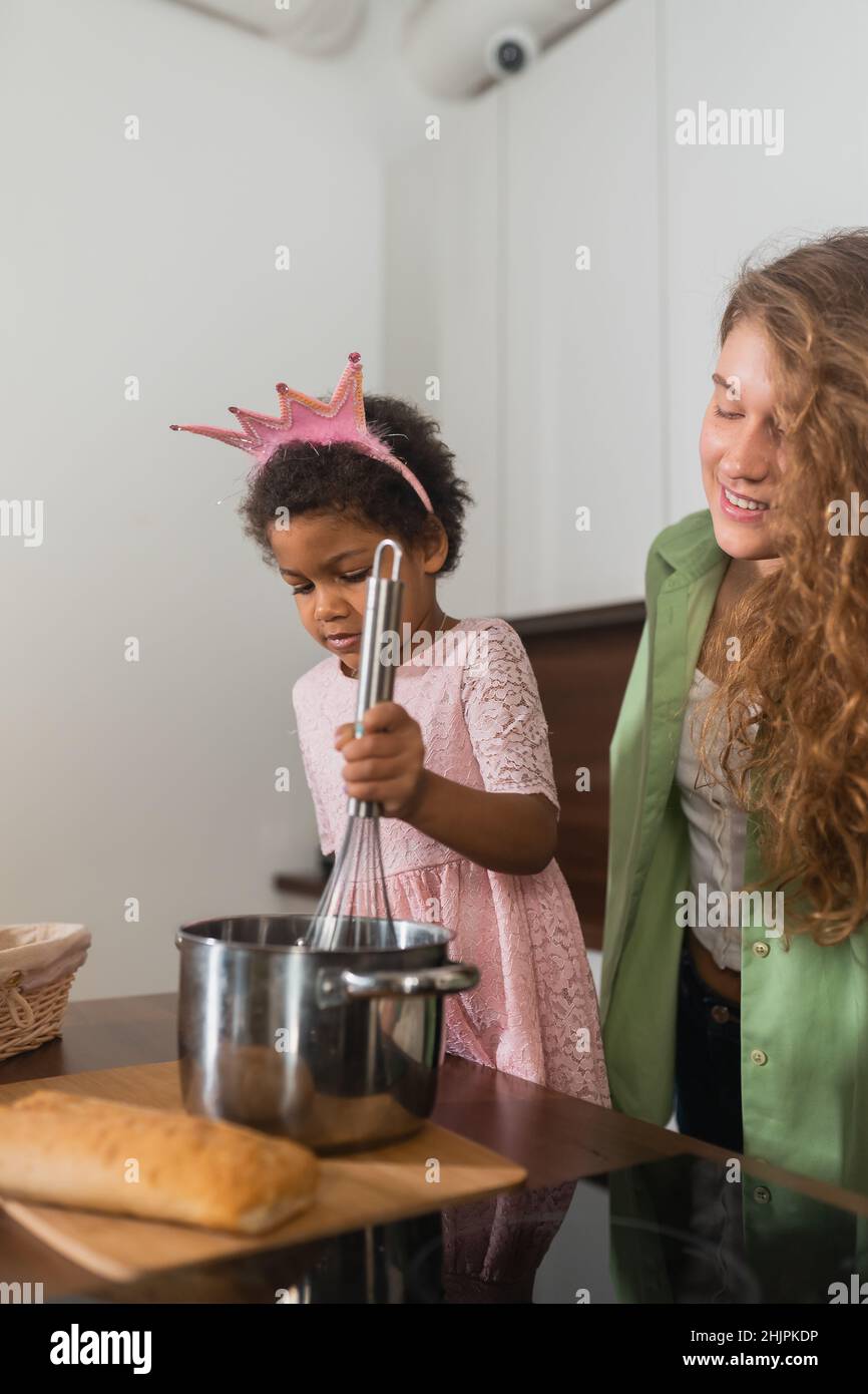 Happy mommy and daughter girl having fun while cooking in kitchen Stock ...