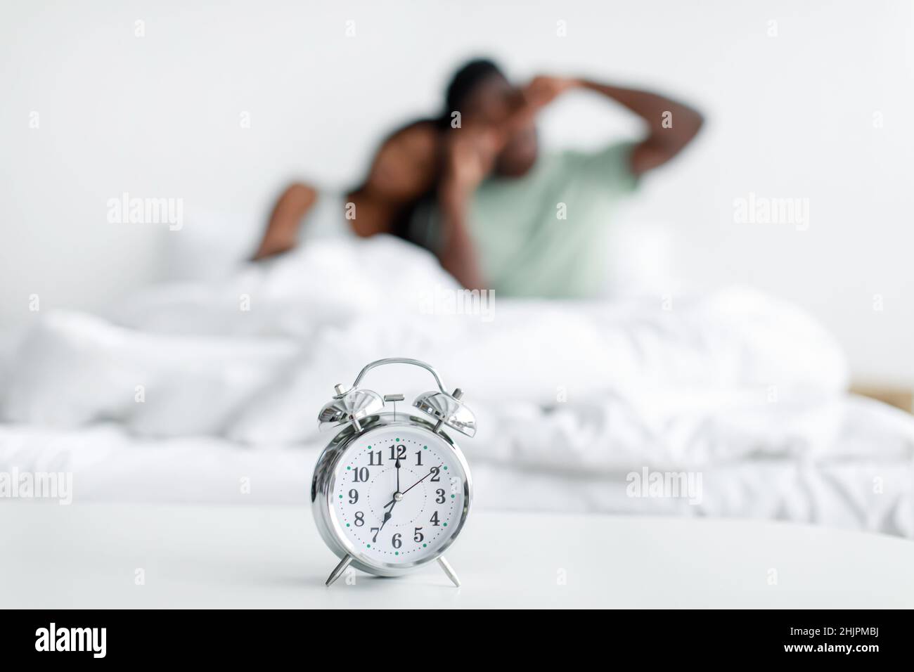 Sleepy young african american man and woman wake up after sleep rubbing ...