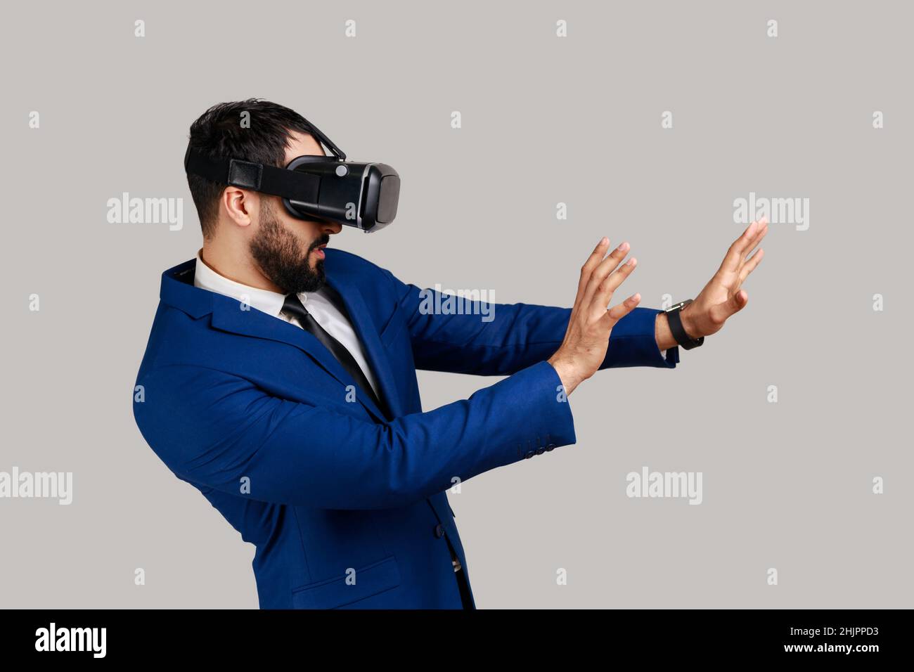 Side view of bearded man in vr glasses, stretching hands forward ...