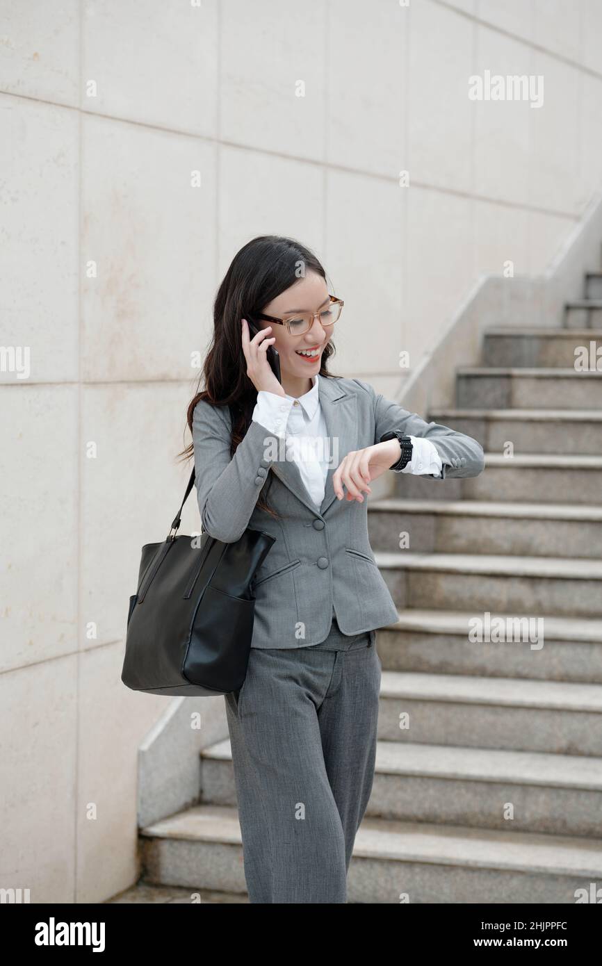 Happy excited young businesswoman reading notification on smartwatch ...
