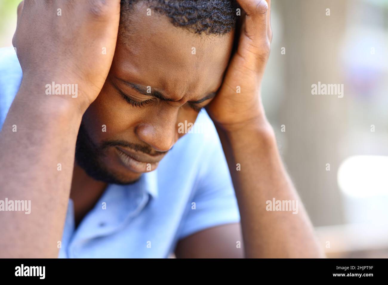 Close up portrait of a worried man with black skin complaining alone in ...