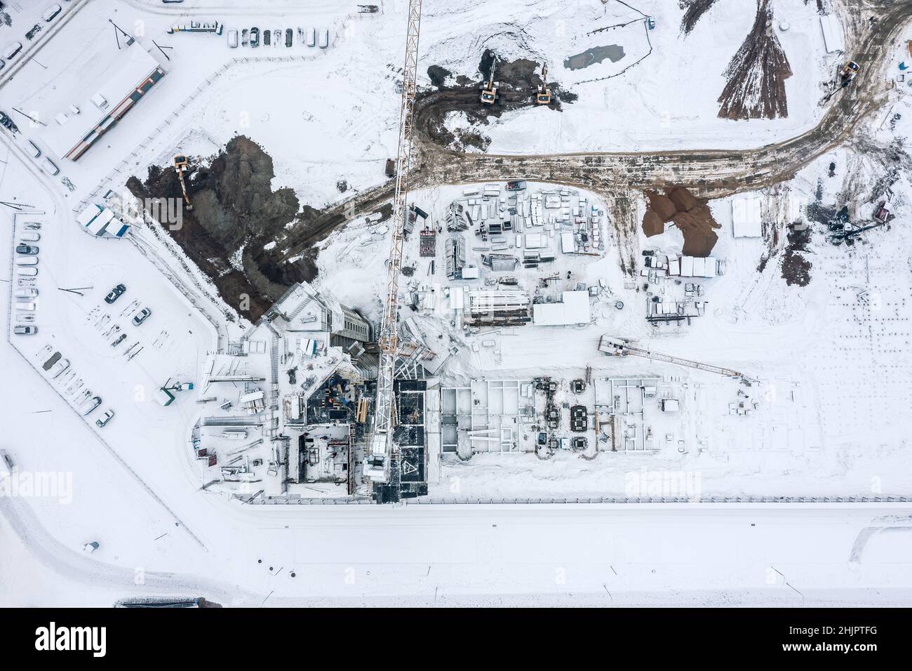 snow-covered construction site in winter with crane and heavy ...