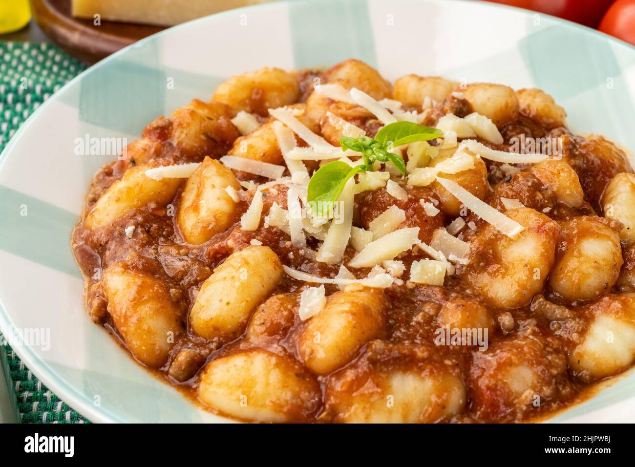 Italian pasta gnocchi on a plate with bolognese sauce, basil and ...
