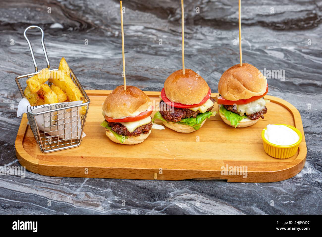 three mini burgers with chicken and meat served with french fries Stock ...