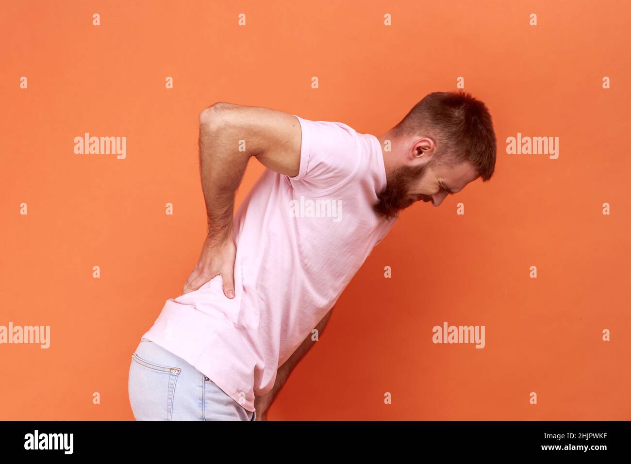 Side view portrait of unhealthy sick bearded man standing and holding ...