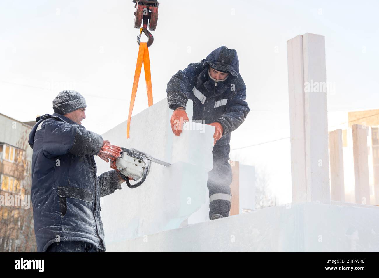 Workers in winter workwear installing ice panels Stock Photo - Alamy