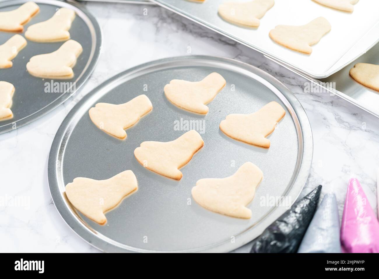 Decorating sugar cookies shaped as figure skates with royal icing Stock ...